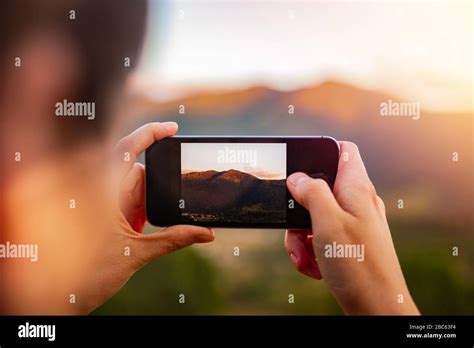 Hands Holding Mobile Phone Taking A Picture In Natural Scenery Stock
