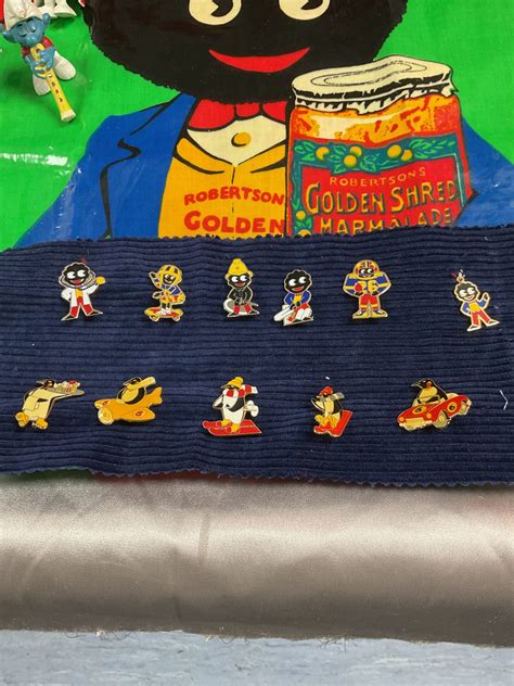 Six Robersons Golly Badges An Apron And Five Penguin Badges And Four