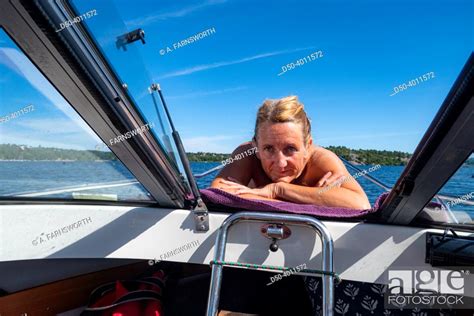 Stockholm Sweden A Woman Sunning On The Deck Of A Small Motorboat
