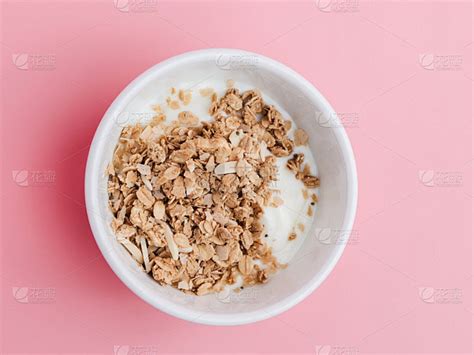 全谷物酸奶在白色的碗粉红色的背景