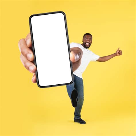 Premium Photo Cheerful Black Man Showing Cellphone Screen Over Yellow