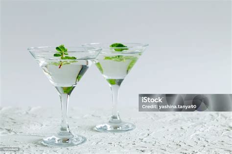 알코올 음료 흰색 배경에 칵테일과 얼음과 마티니 안경 두 테이블에 라임과 녹색 민트와 칵테일 마가리타 복사 공간을 복사합니다 0