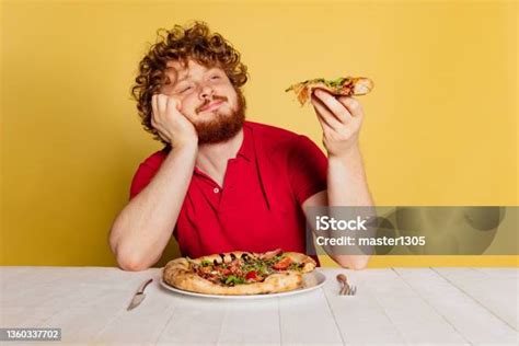 노란 스튜디오 배경에 고립 된 맛있는 이탈리아 피자를 시음하는 붉은 수염남자의 초상화 피자에 대한 스톡 사진 및 기타 이미지