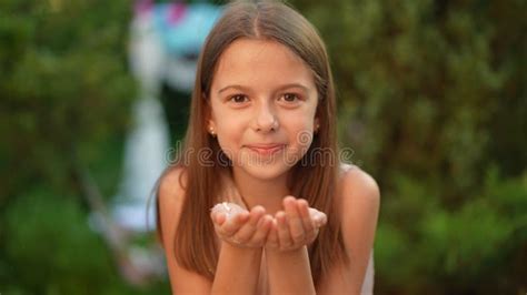 Headshot Front View Of Smiling Caucasian Girl Blowing White Confetti