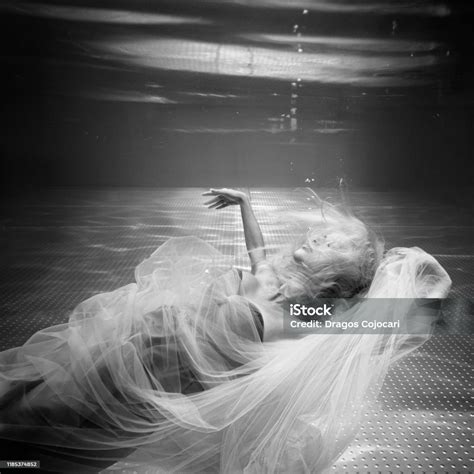 흑백 이미지입니다 수중 금발은 비행 드레스를 입고 수영장에서 수영 수중 공간을 복사합니다 검은색에 대한 스톡 사진 및 기타