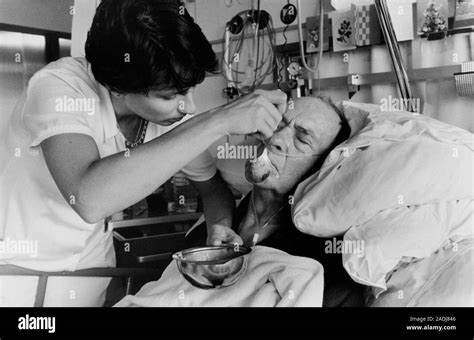 Patient Being Spoon Fed A Nurse Spoon Feeds A Very Sick Man In A