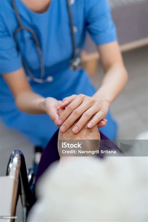간호사 또는 의사의 손을 감아 휠체어에 앉아있는 노인 여성의 손을 잡고 진료소나 병원 센터에서 노인을 돌보고 지원합니다 건강관리와 의술에 대한 스톡 사진 및 기타 이미지