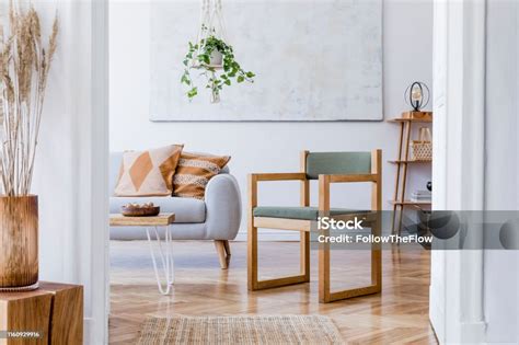 디자인 안락 의자 회색 소파 나무 커피 테이블 선반 식물 꽃과 우아한 개인 액세서리와 아늑한 아파트에서 휴식 공간의 현대적인 보헤미안 인테리어 세련된 홈 장식 템플릿 0명에