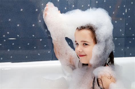 Premium Photo Smiling Girl Playing With Soap Sud In Bathtub