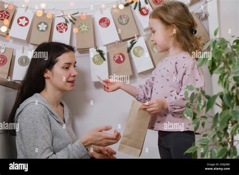 Mère Avec Enfant Ouvrant Noël Calendrier Des Tâches Et Des Cadeauxla