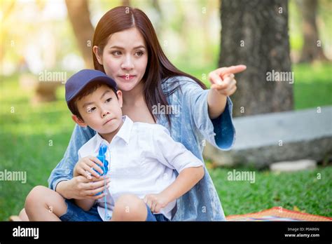 Beautiful Asian Mother Playing With Her Lovely Son Hand Pointing To