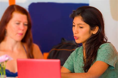 노트북 컴퓨터와 사무실 카페에서 일 하는 두 젊은 행복 하 고 아름 다운 백인과 라틴어 여자의 라이프 스타일 초상화 디지털 비즈니스 파트너 및 다양성 민족 친구와 논의 2