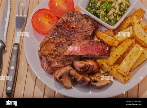 Medium Rare Rump Steak With Chipsmushrooms And Tomatoes With A