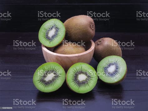 검은 나무 배경에 나무 그릇에 신선한 육즙 맛 있는 하 고 건강 한 키 위 과일의 쪼 갠 다 개체 그룹에 대한 스톡 사진 및