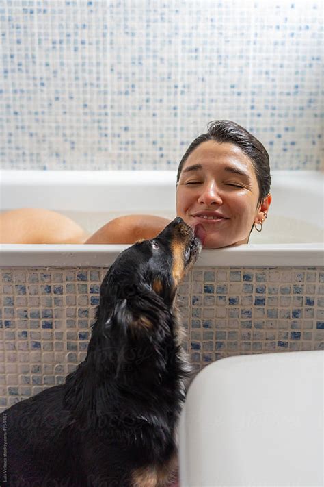 Woman Taking A Bath And Kissing To Her Dog By Stocksy Contributor