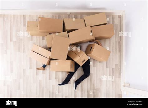 Close Up Of Couple Lying Under The Heap Of Cardboard Boxes On Floor Stock Photo Alamy
