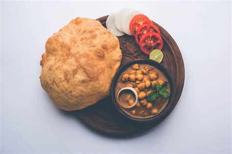Chole Bhature 또는 병아리 완두콩 카레와 튀김 푸 리 흰색 배경 위에 테라코타 그릇에 제공 됩니다 선택적 초점 병아리