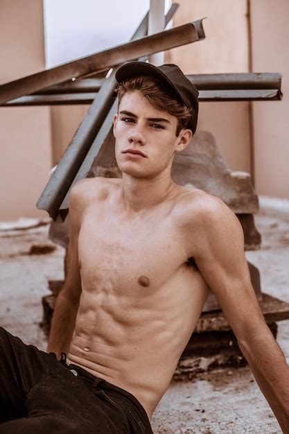 Premium Photo Portrait Of Man Sitting Against Built Structure