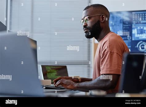 Side View Portrait Of Black Software Developer Using Computer In High