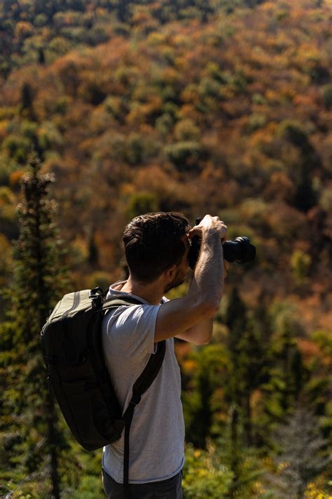 Foto Hombre Con Camiseta Blanca Sosteniendo Una Cámara Dslr Negra