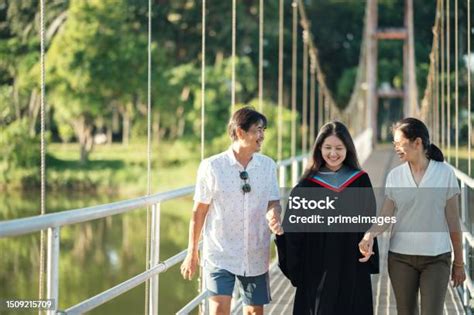 딸과 함께 행복한 쾌활한 미소를 지으며 사랑스러운 순간을 보내는 졸업생의 자랑스러운 아시아 가족 20 24세에 대한 스톡 사진