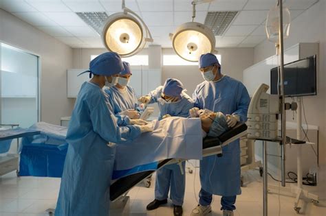 Médico enfermeira fazendo cirurgia em paciente Foto Premium