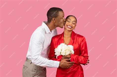 Premium Photo Black Man Kissing Womans Cheek She Holds Flowers Love