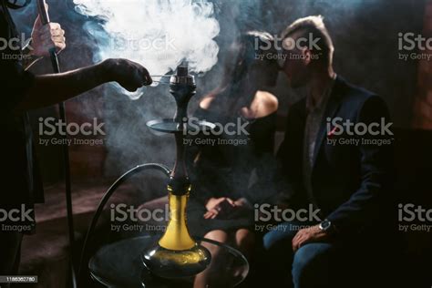 후카 라운지 컨셉 아름다운 커플 여자와 남자 백라이트에 사랑 흡연 Hookah과 바에서 칵테일을 마십니다 연기 구름에 전경에