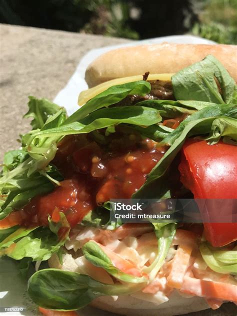 바베 큐 체 다 치즈 슬라이스 패스트 푸드 비프 햄버거 패티 구운 참 깨 롤빵 치즈 버거 혼합 샐러드 양상추 잎 양파 토마토 양념 츠 니 케첩 소스를 먹고 야외 공원