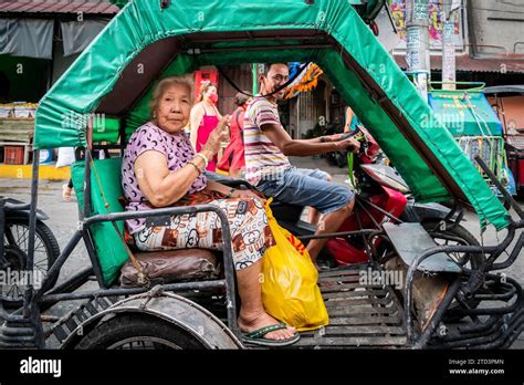 An Old Filipino Lady Carries Her Shopping On A Trike Or Tuk Tuk Through