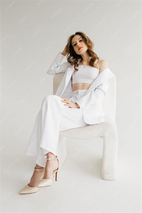 Premium Photo Pretty Girl In A White Trouser Suit Against A White