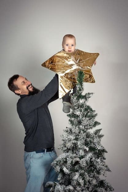 Papá Sosteniendo Al Bebé Como La Copa Del árbol Foto Premium