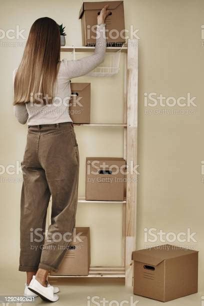 소녀는 나무 선반에 종이 상자를 구성합니다 친환경 보관 및 포장 35 39세에 대한 스톡 사진 및 기타 이미지 35 39세 가구 가정의 방 Istock
