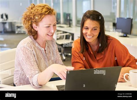Businesswoman Helps Trainee Or Trainee On Laptop Computer During IT