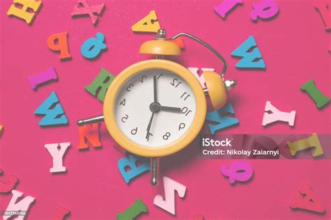 빨간 배경에 임의의 다채로운 알파벳과 노란색 알람 시계 다채로운 문자 맨 위 보기입니다 벽 시계에 대한 스톡 사진 및 기타
