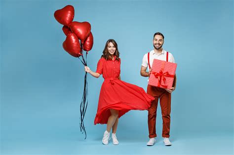 생일 휴가 파티를 축하하는 흰색 빨간 옷을 입은 전체 재미있는 젊은 커플 친구 남자 여성은 파란색 배경에 고립 된 선물로 공기