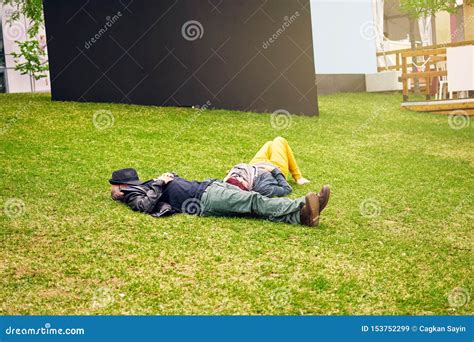 Adult Couple Lying On The Grass Field And Taking A Nap Man S Face Is Covered With His Hat
