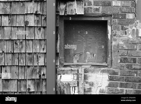 An Old Worn And Weathered Brick Building Blocked With Plywood Infill In