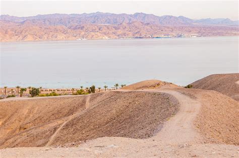 샌 디는 사막 산 홍 베이 쇼 어와 배경에 요르단 해안과 Eilat 이스라엘에서 해변에서에서 도보 경로 곡선 거리에 대한 스톡