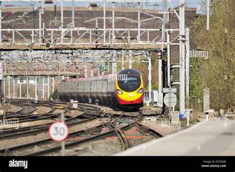 Virgin Pendolino Express Passenger Train Tilting On The Approach To Stafford Station Stock Photo