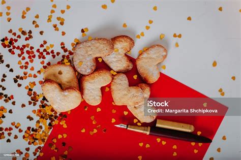 나무 만년필이 있는 빨간 종이에 하트 모양의 쿠키 하트 모양의 세인트 발렌타인 쿠키와 흰색 배경에 황금 빛빛 빨간 종이에 황금 반짝임 0명에 대한 스톡 사진 및 기타 이미지