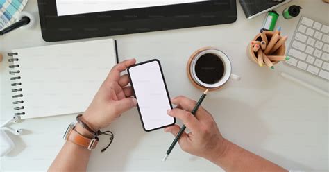 사무용품이 있는 직장에서 빈 화면 스마트폰을 들고 있는 디자이너의 상위 뷰 사진 Unsplash의 태국 이미지