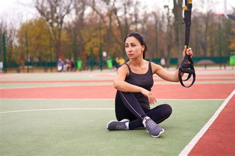 Premium Photo Girl Athlete Training Using Trx On Sportground