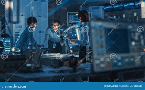 Diverse Team Of Engineers With Laptop And A Tablet Analyse And Discuss
