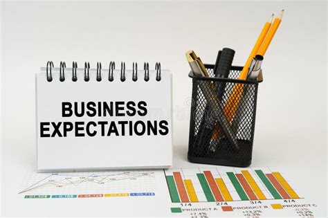 On The Table Are Business Charts Office Supplies And A Notepad With