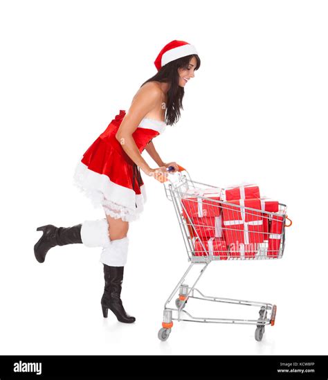 Woman In Santa Claus Pushing Cart With Present Over White Background
