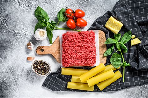 갈은 쇠고기와 카넬로니 파스타를 요리하는 개념 재료 바질 체리 토마토 파르메산 마늘 회색 배경 맨 위 보기 0명에 대한 스톡