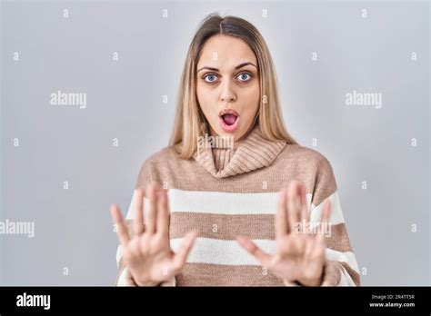 Young Blonde Woman Wearing Turtleneck Sweater Over Isolated Background