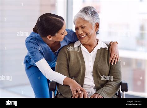 Healthcare Disability And A Nurse Hugging An Old Woman In A Wheelchair
