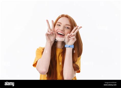 Portrait Of Cheerful Young Woman Showing Two Fingers Or Victory Gesture